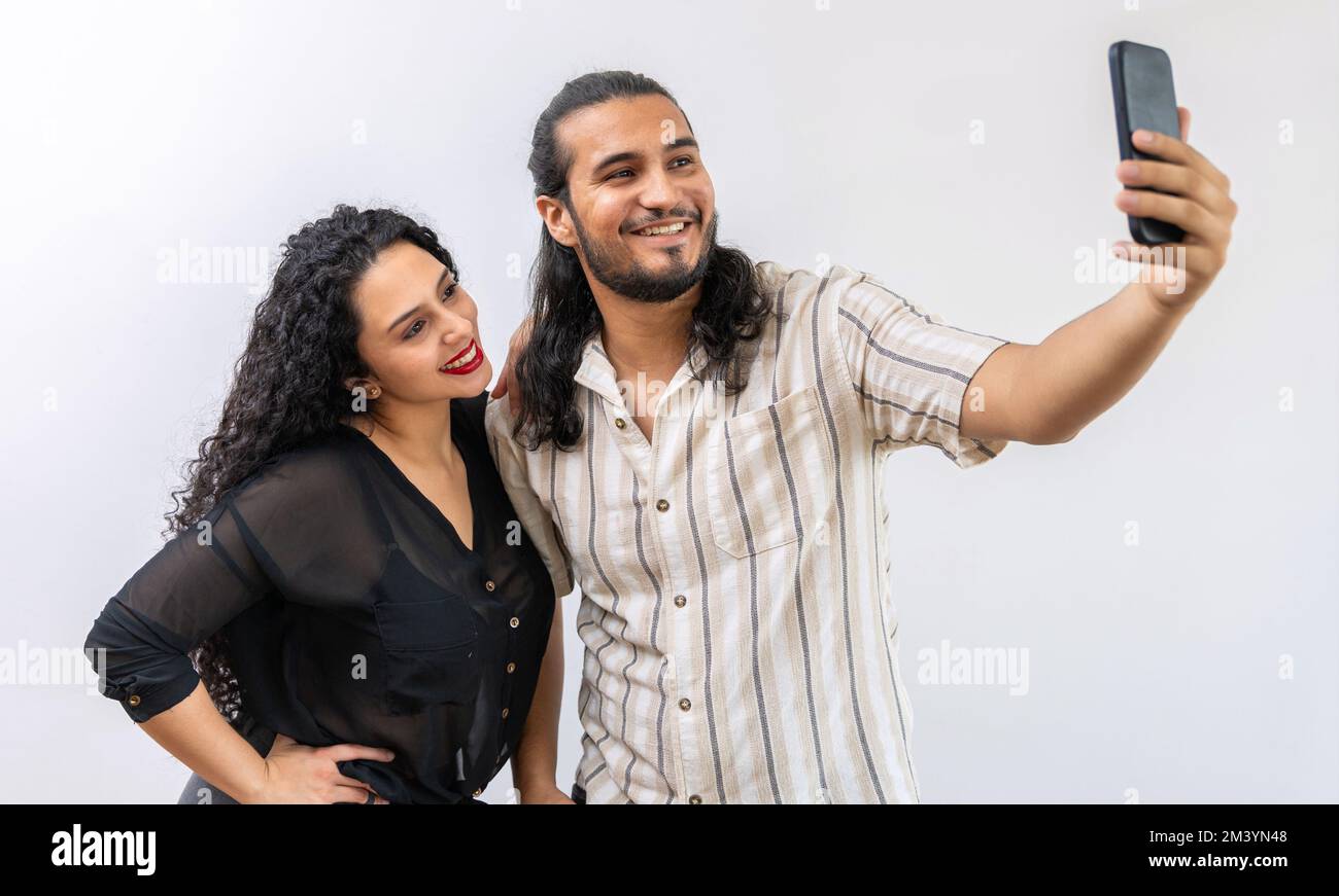 Young latin couple smiling happy and making selfie in isolated ...