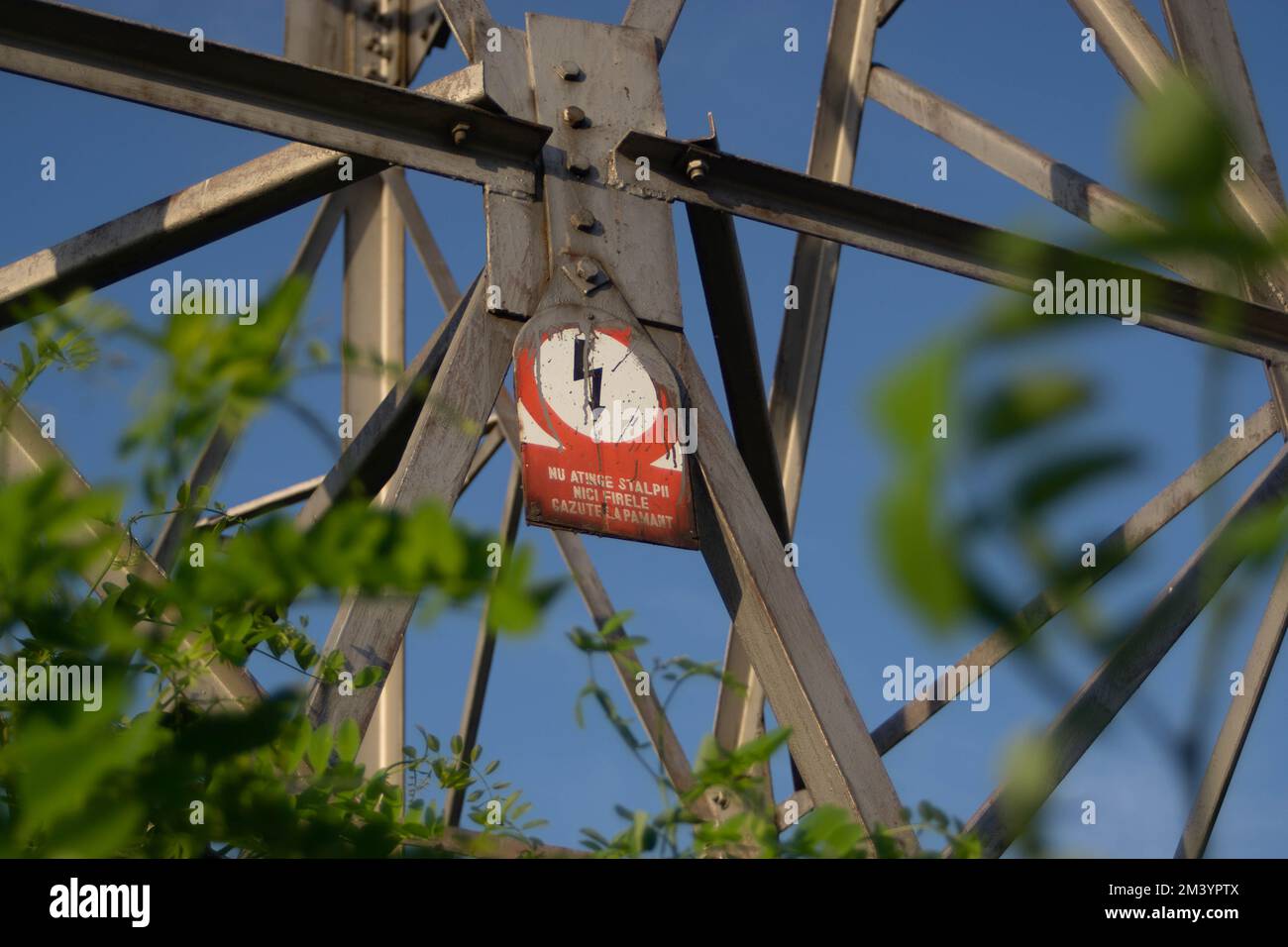 A sign on a transmission tower warning about the high voltage Stock ...