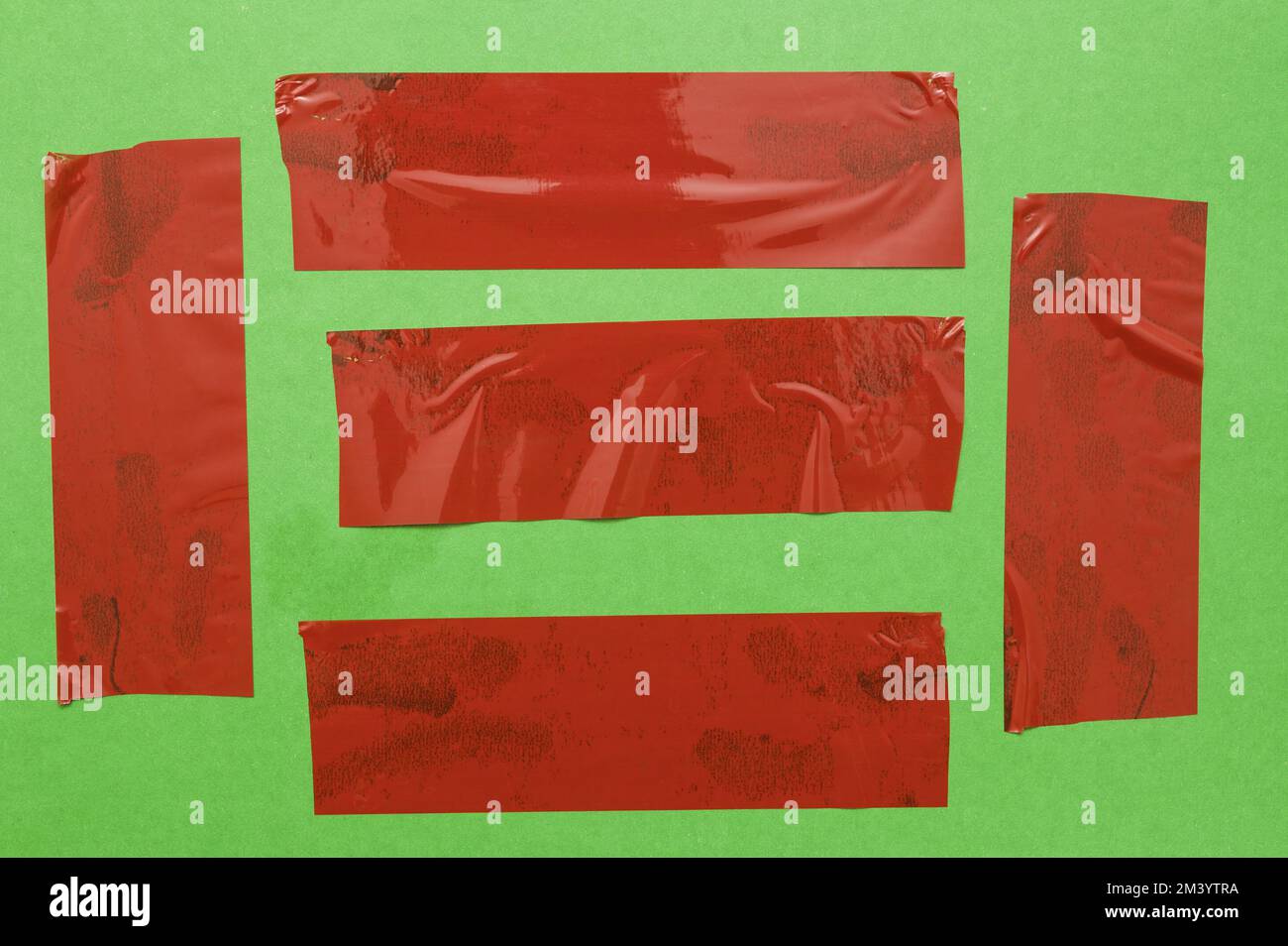 Different red tape parts green wall Stock Photo - Alamy
