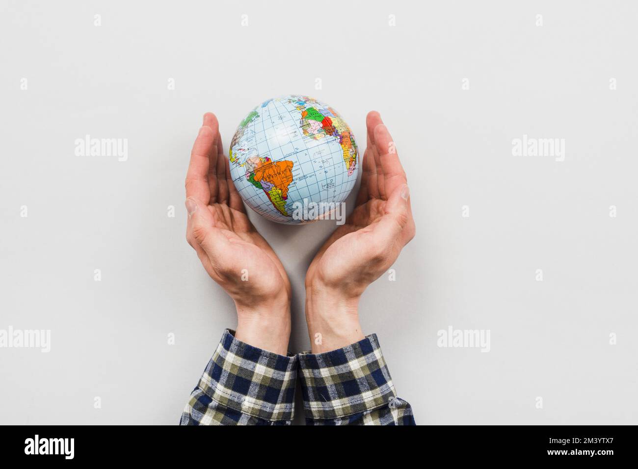 Earth globe surrounded by hands Stock Photo - Alamy