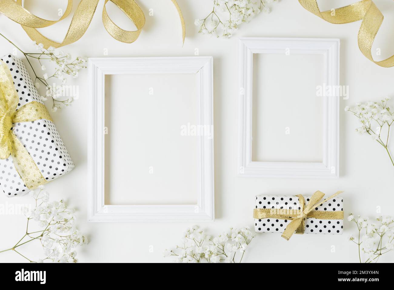 Golden ribbon gift boxes baby s breath flowers near wooden frame white ...