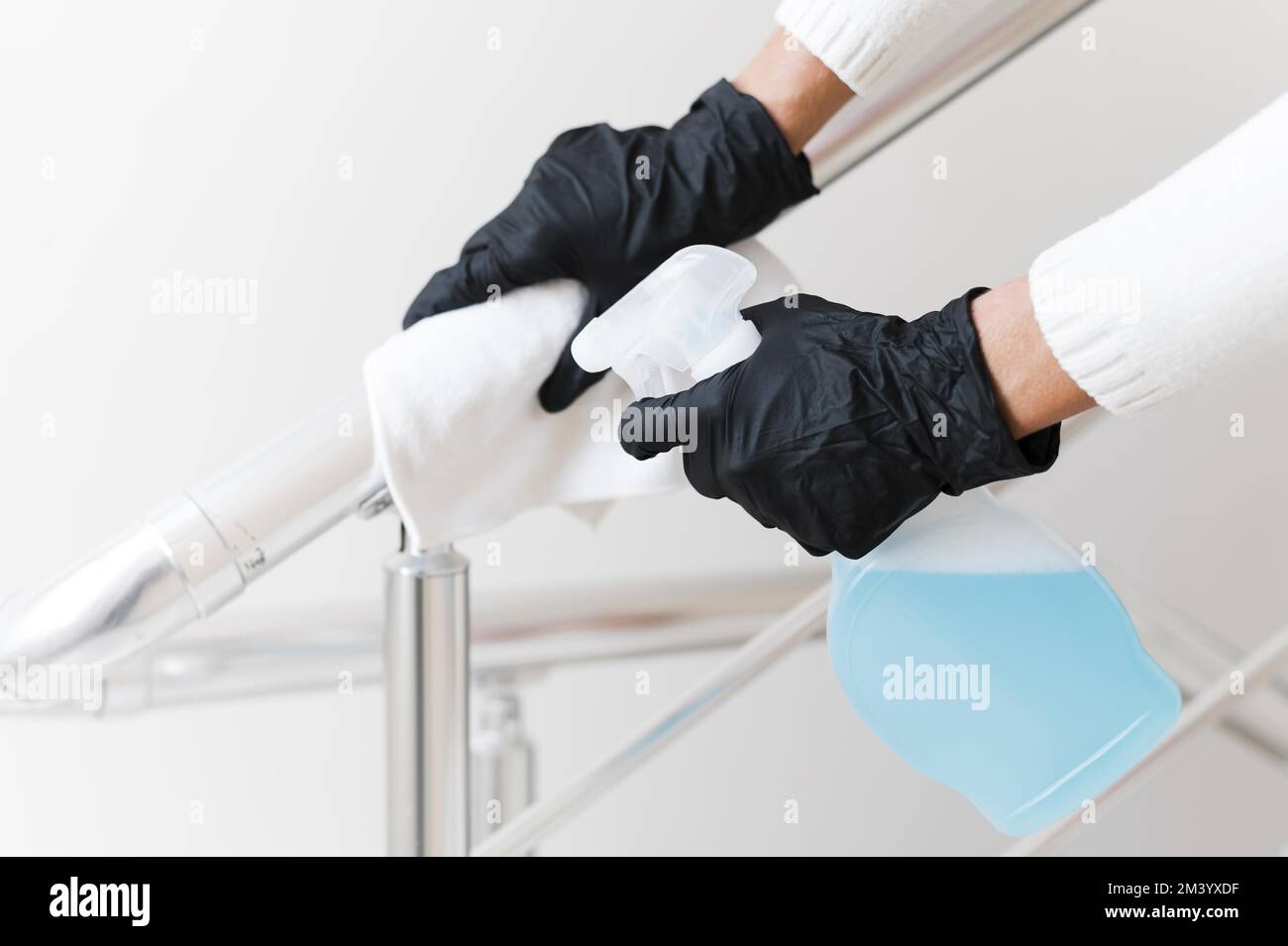 Hands with gloves disinfecting hand rail Stock Photo - Alamy