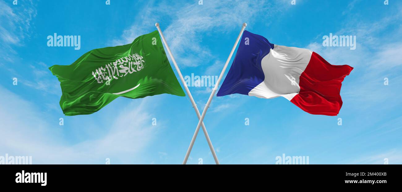 two crossed flags France and Saudi Arabia waving in wind at cloudy sky ...