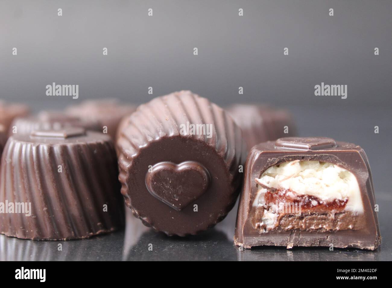 a chocolate candy case creamy slice in a section on a black background ...