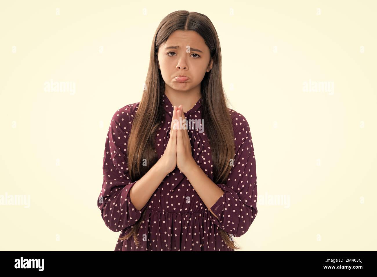 Funny face. Teenager child girl praying with sad expression over white ...