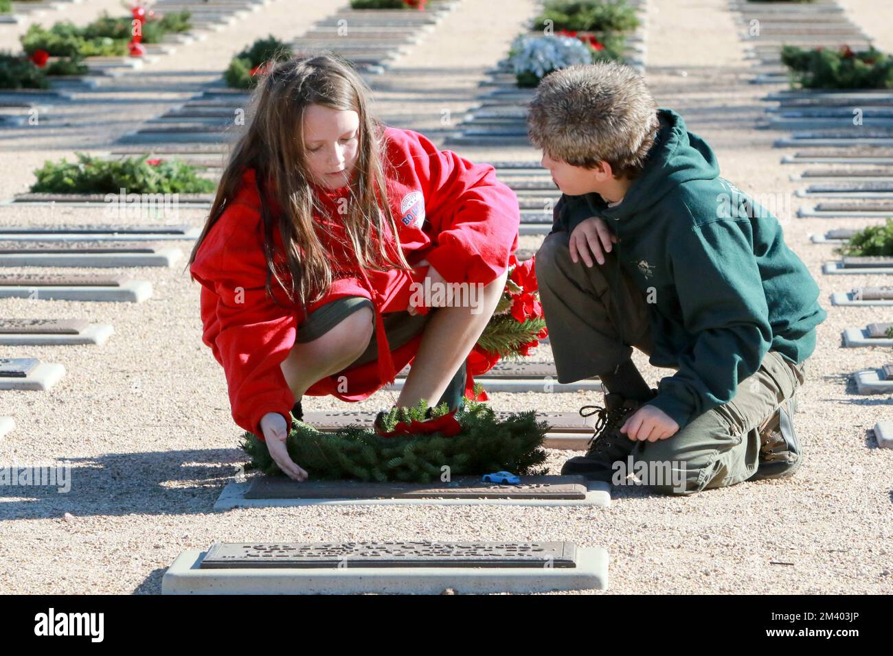 Children lay a wreath at a headstone during the annual Wreaths Across ...