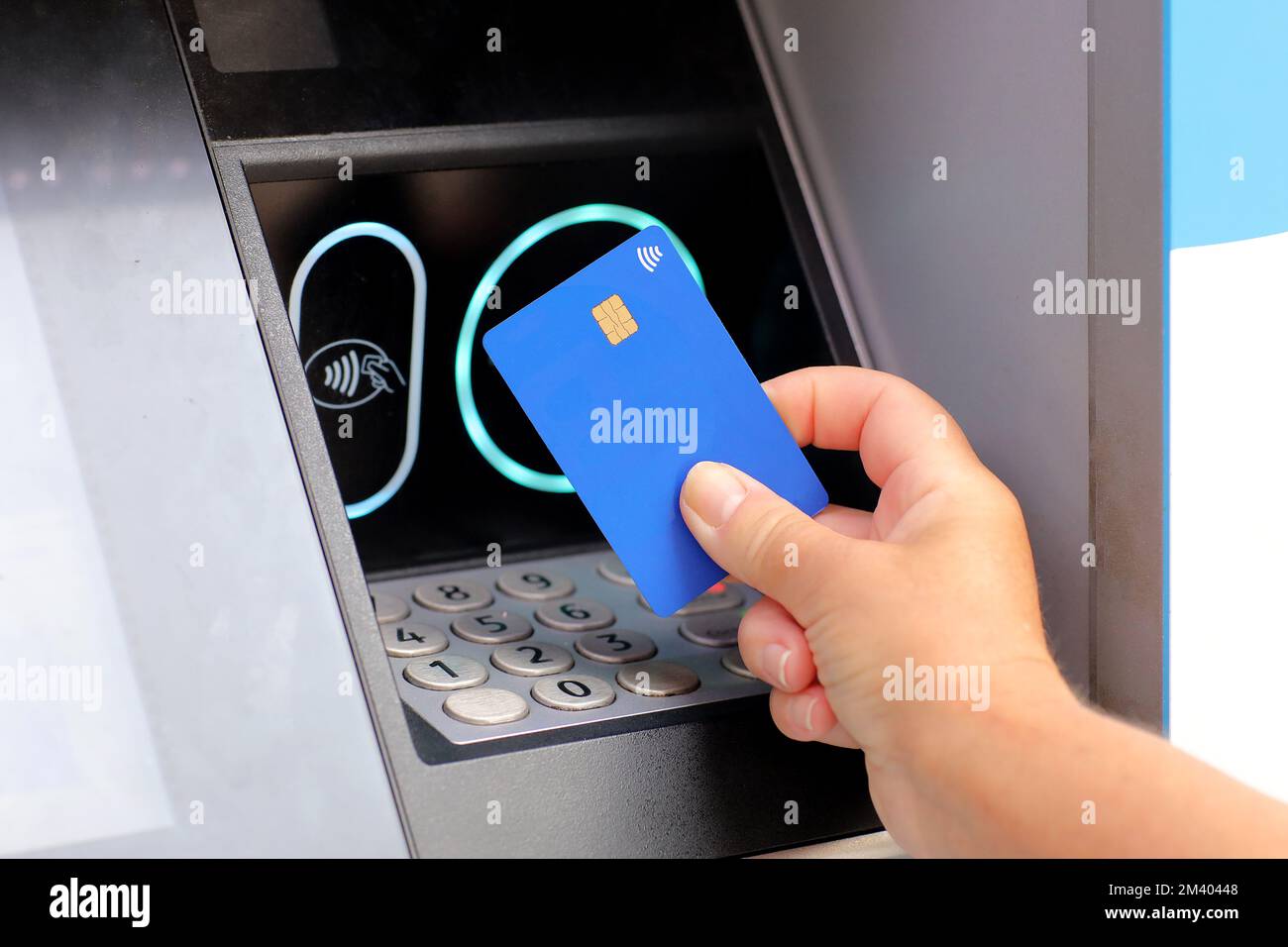female hand with card by ATM. hand with credit card withdrawing money from ATM using NFC ...