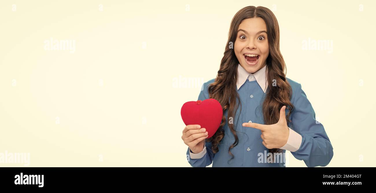 Surprised child with open mouth point index finger at red heart ...