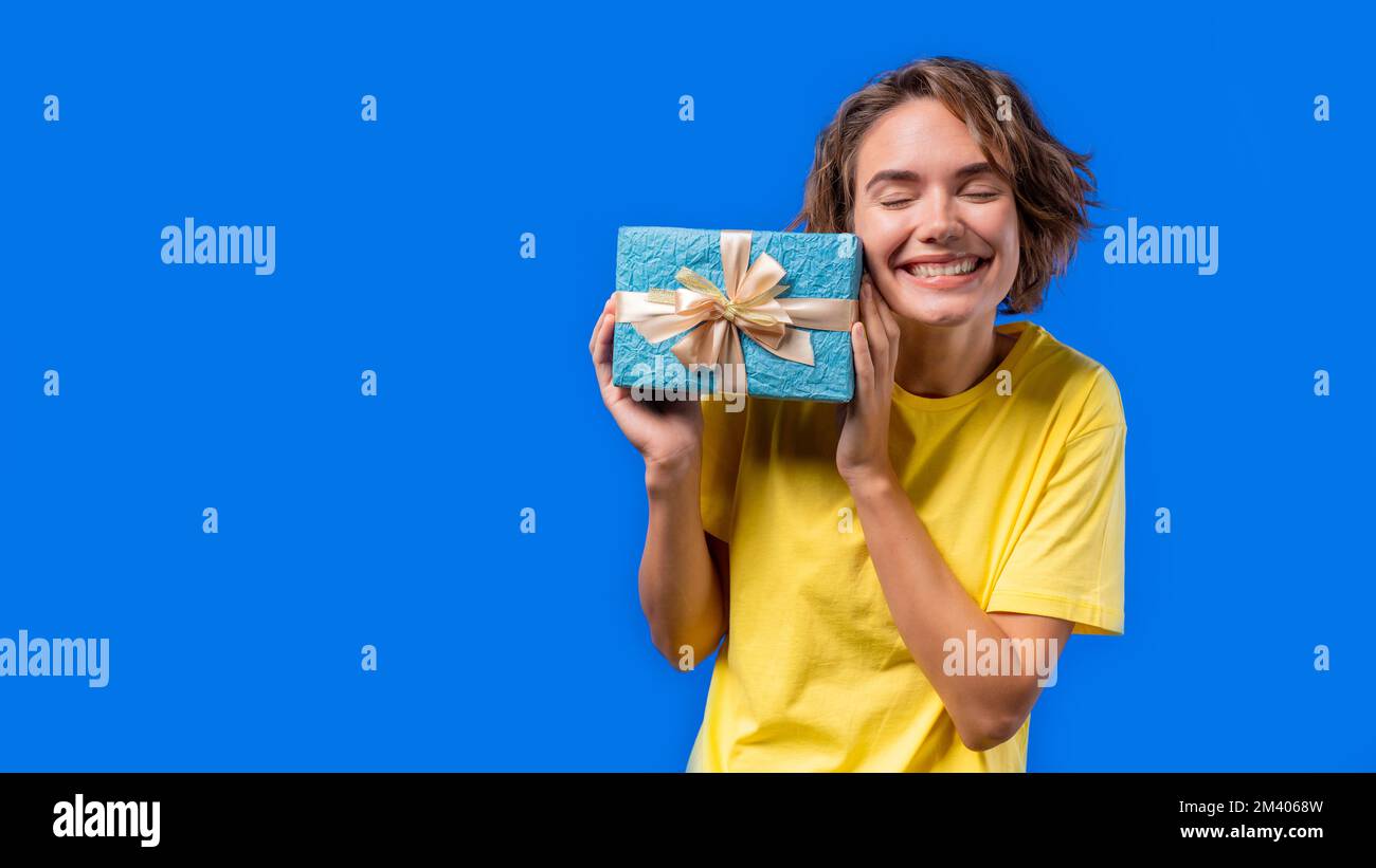 Happy birthday woman with gift box on blue background. Girl smiling ...