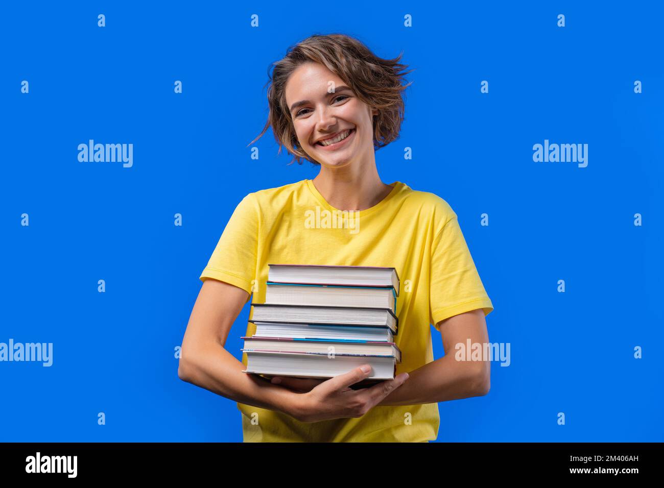 Clever student woman holds stack of university books from college ...