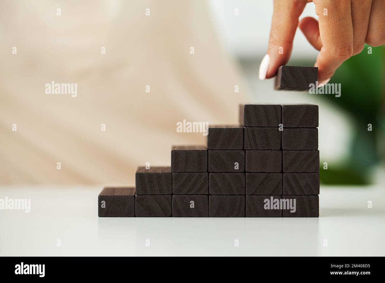 Woman hand arranging wood cube stacking as stair step shape Stock Photo ...