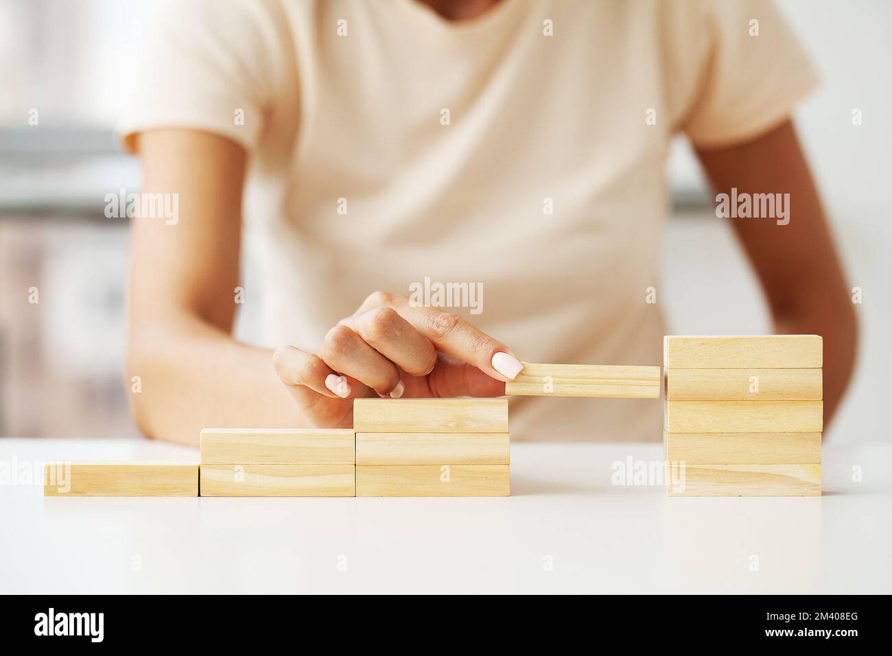 Woman hand arranging wood cube stacking as stair step shape Stock Photo ...