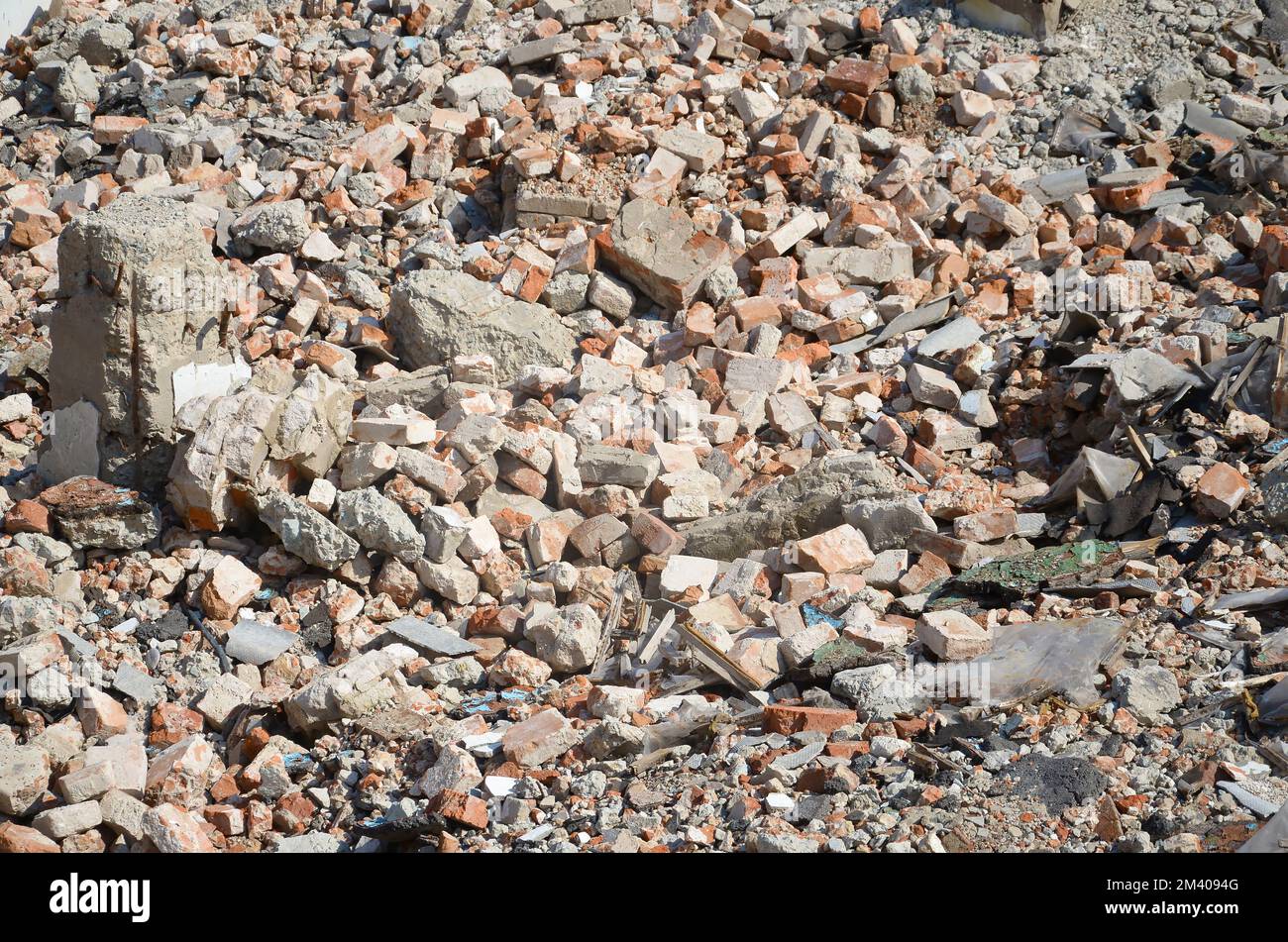 Pile of broken red bricks and fragments of concrete from destroyed building. Broken bricks close ...