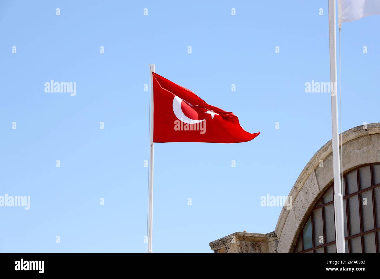 Turkish flag on flagpole waving in clean blue sky background. White ...