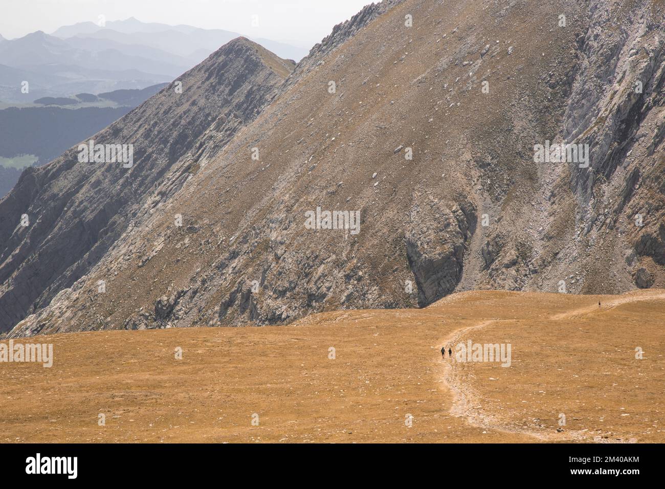 A view of People walking in a landscape showing mountains in the ...