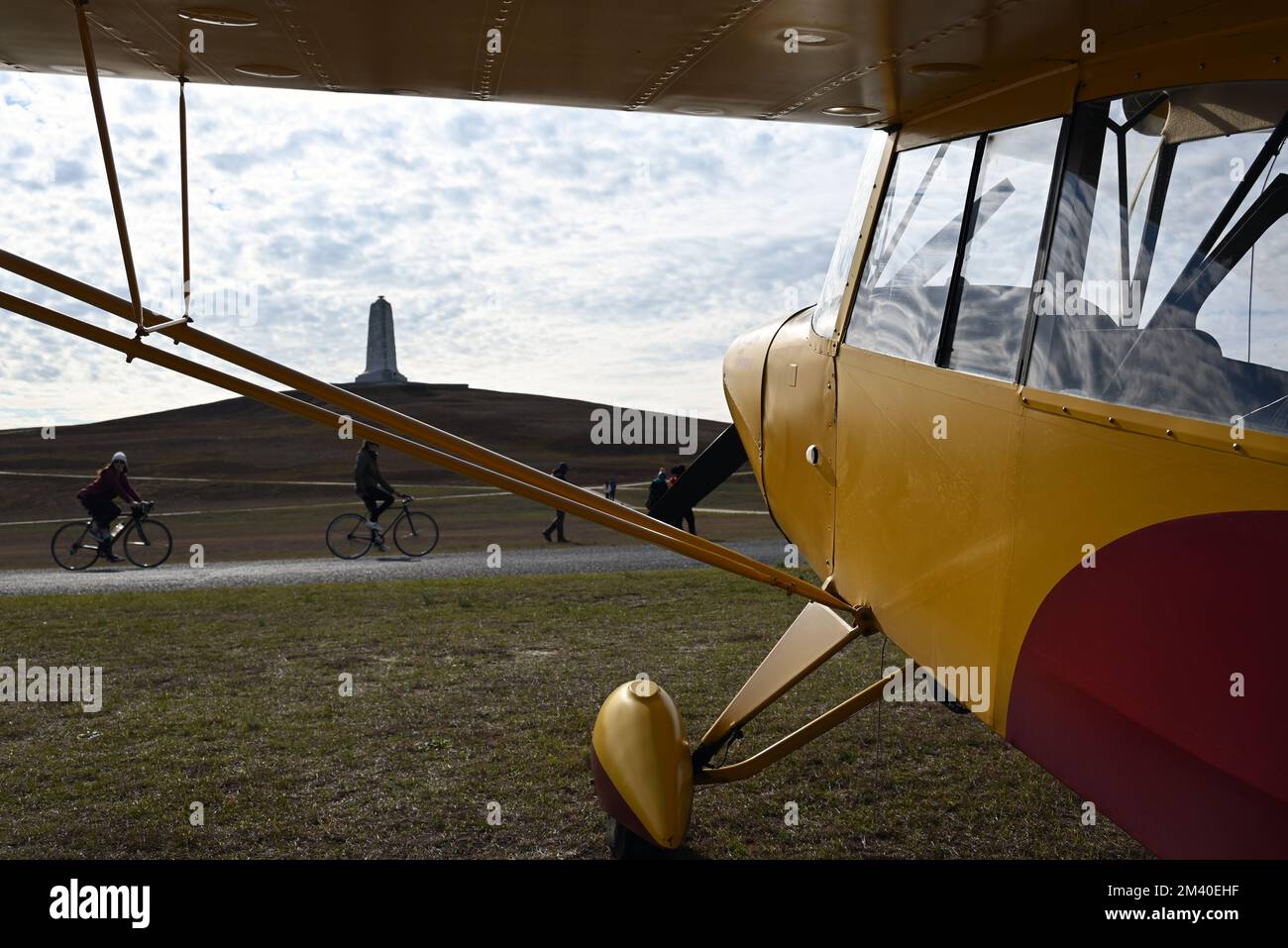 Vintage aircraft park on the field in front of the hill with the Wright ...