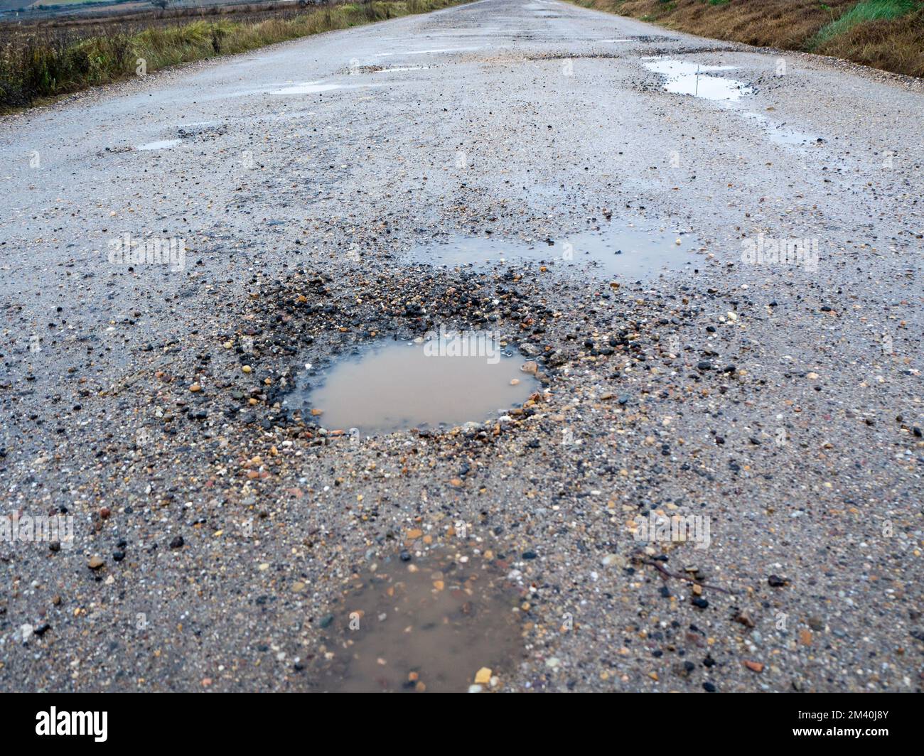 Pothole on a paved road on a rainy winter day. Concept of risk and ...
