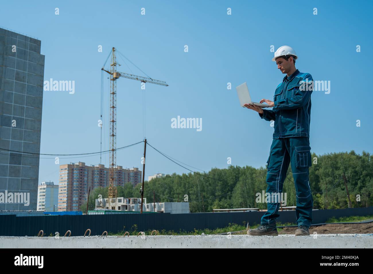 A male builder in a helmet stands against the background of a ...
