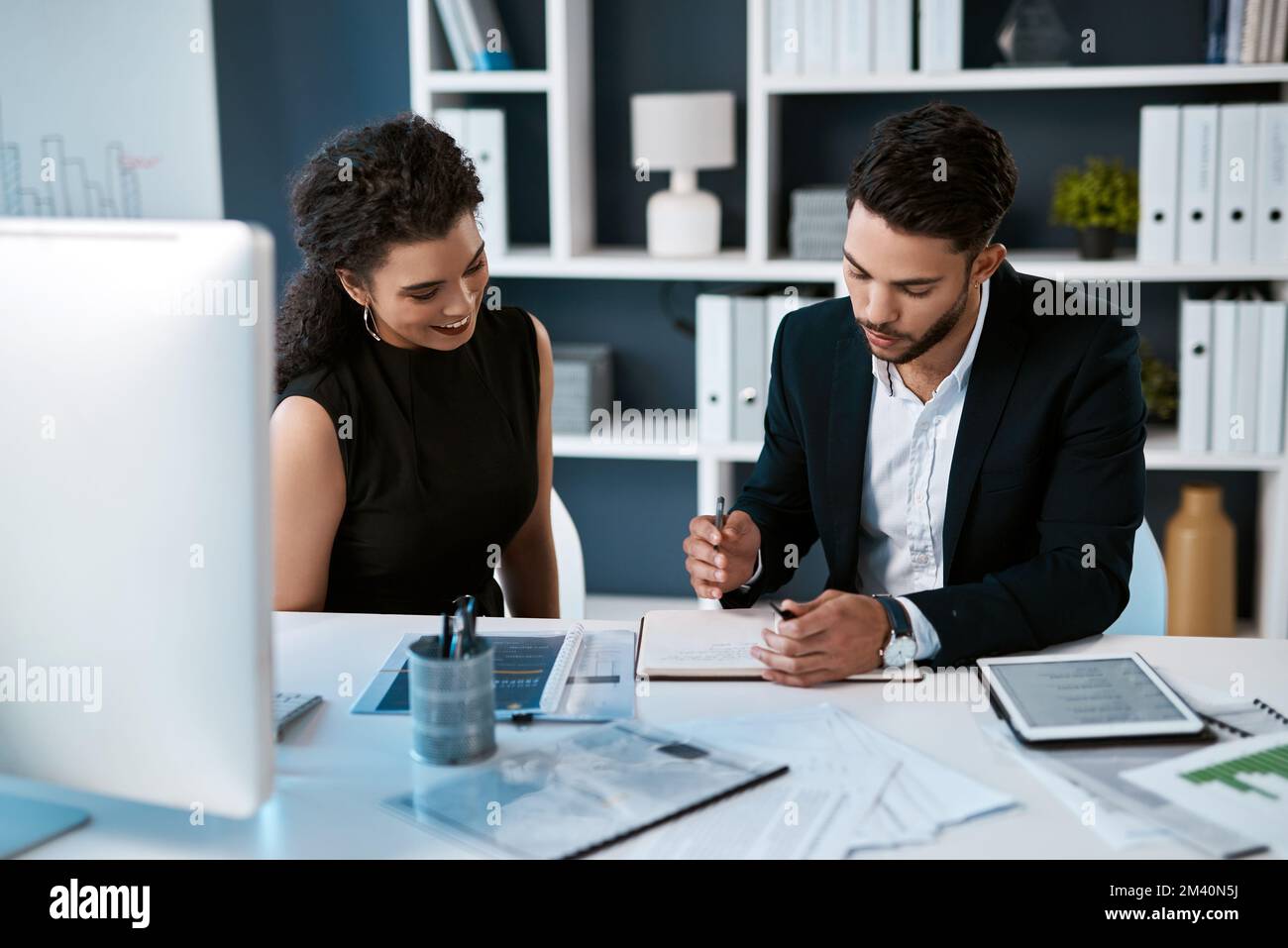 Coming up with ideas together. two young businesspeople sitting ...