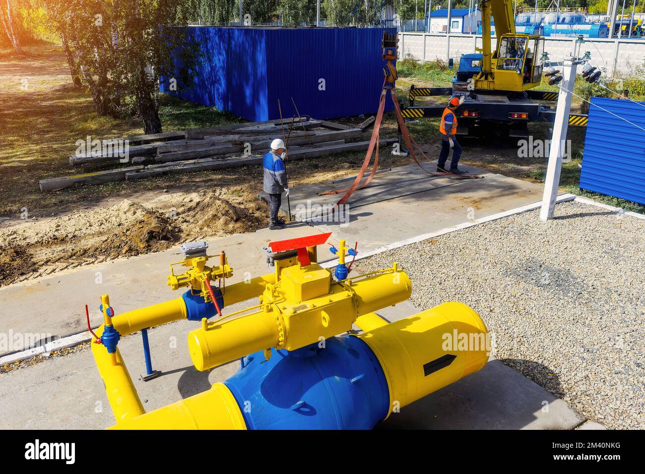 Two workers in construction helmets and overalls laying concrete slab ...