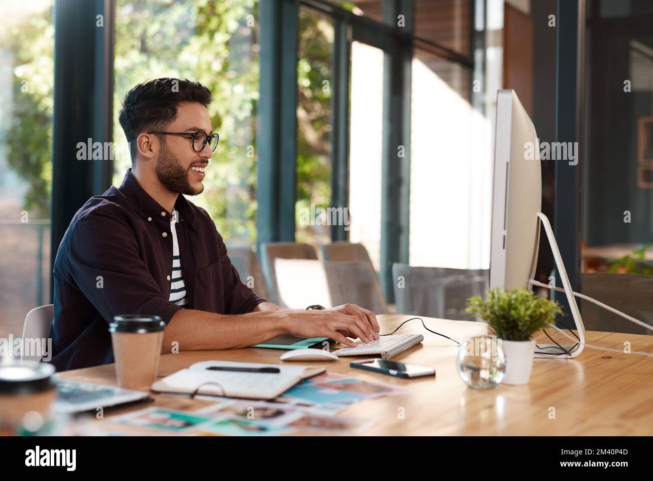 I love my job. a handsome young businessman sitting alone in his office ...