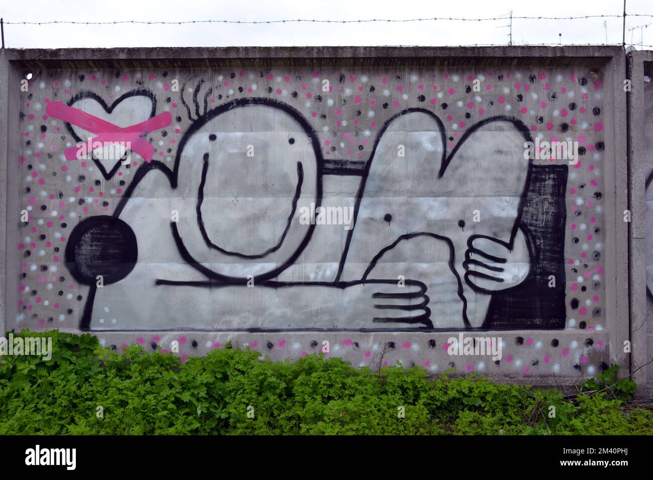 Graffiti, drawn with a white, black, pink spray drawing of a man in the ...