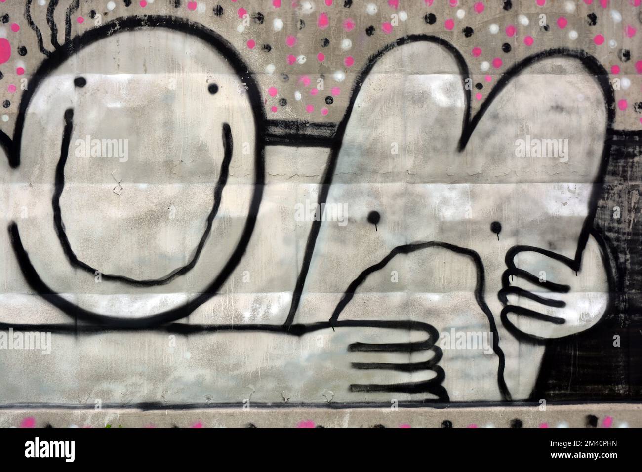 Graffiti, drawn with a white, black, pink spray drawing of a man in the ...
