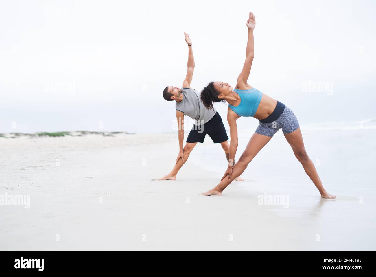 Every stretch is a transformative one. a young man and woman practising ...