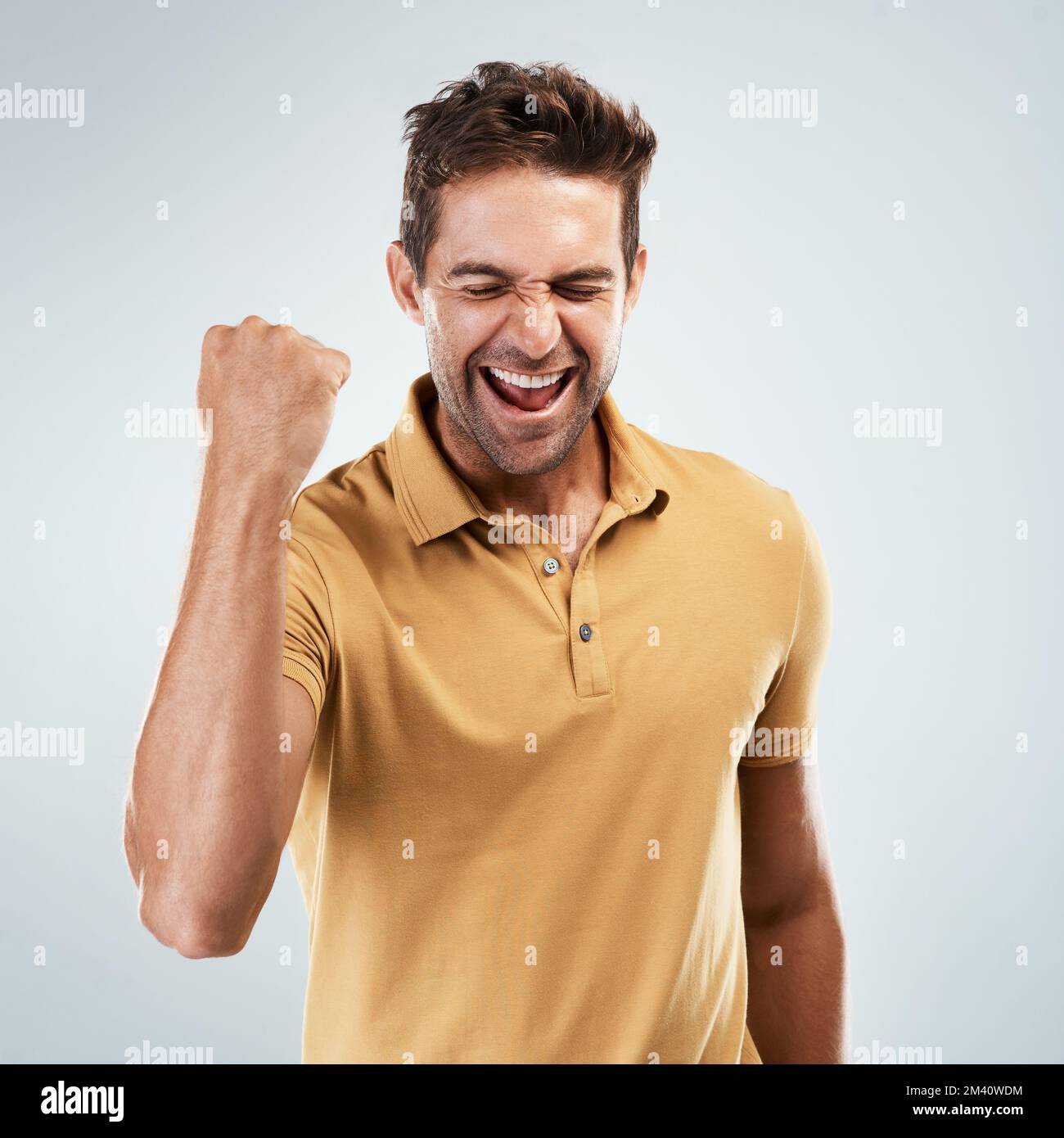 Finally Im winning. Studio shot of a cheerful young man punching the ...