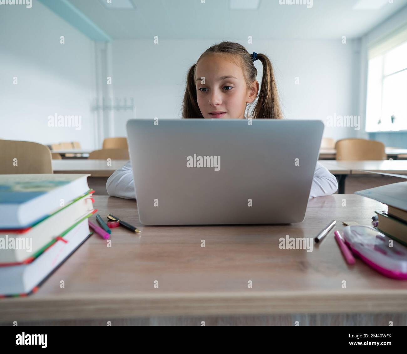 Caucasian girl studying on a laptop in a classroom Stock Photo - Alamy