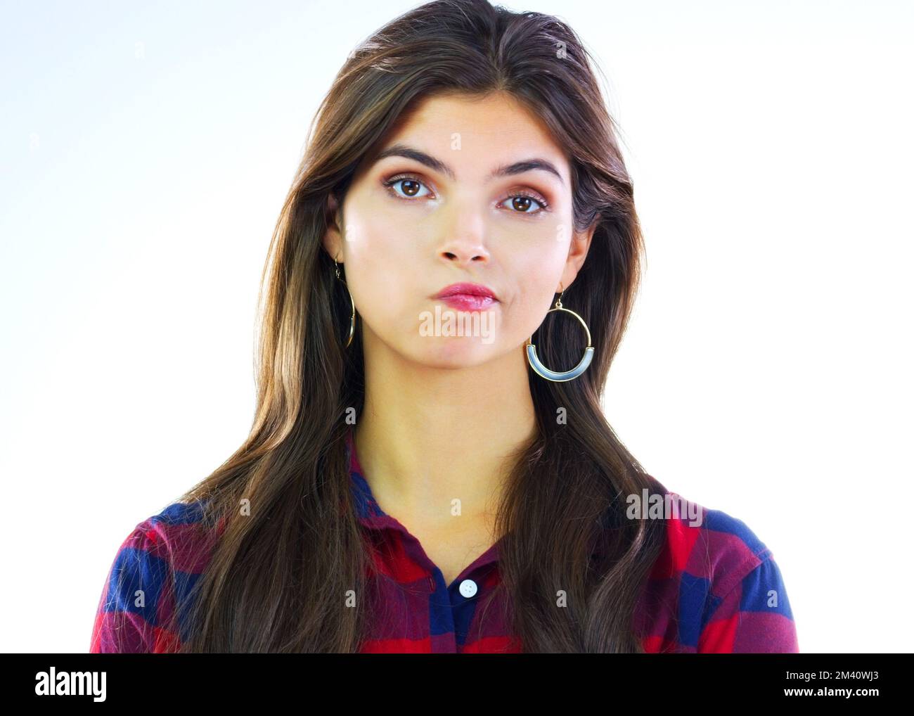 Deciding is never never easy. a young woman posing against a white ...