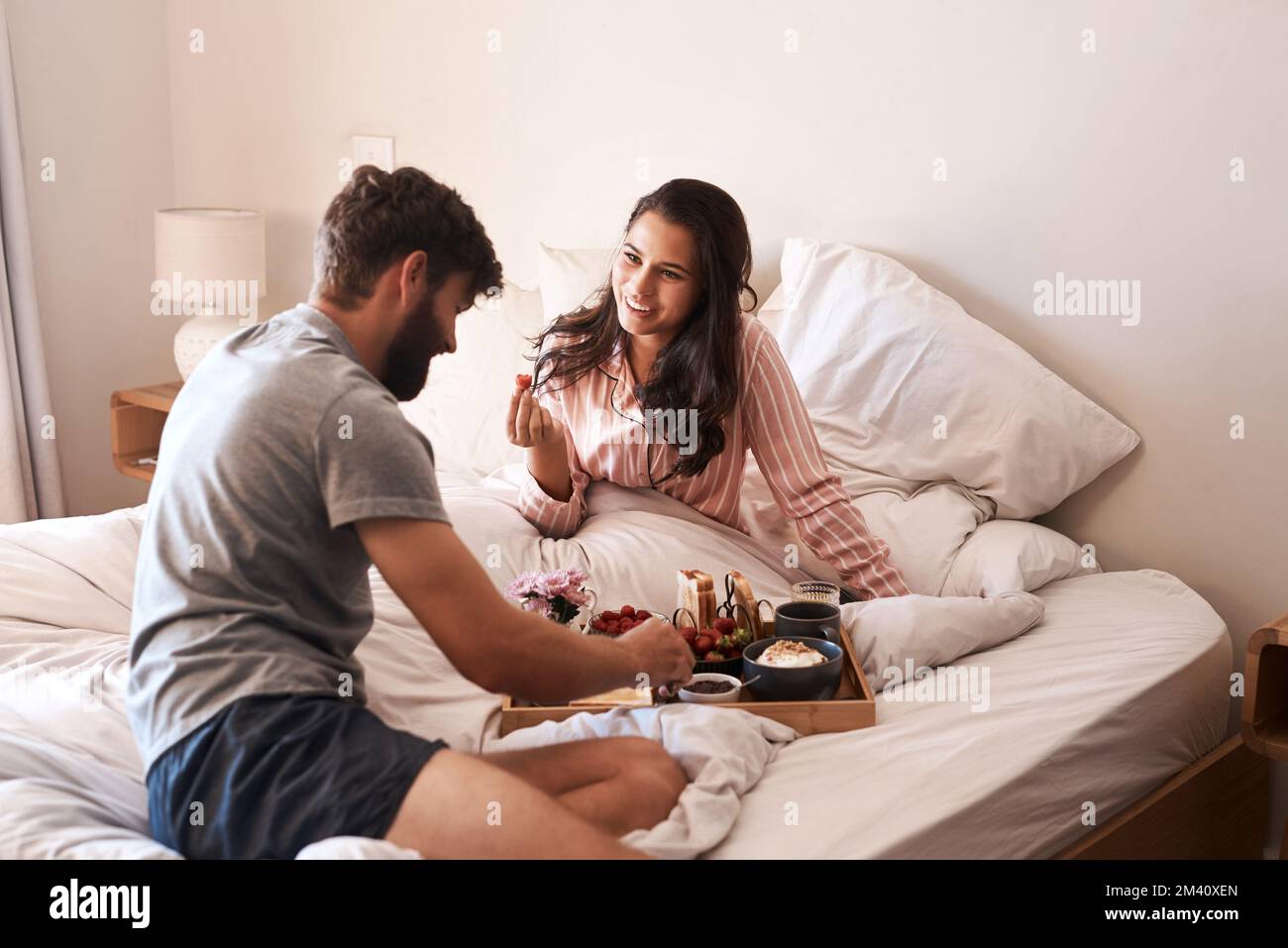 Nothing breaks routine like romantic gestures. a happy young couple enjoying breakfast in bed ...