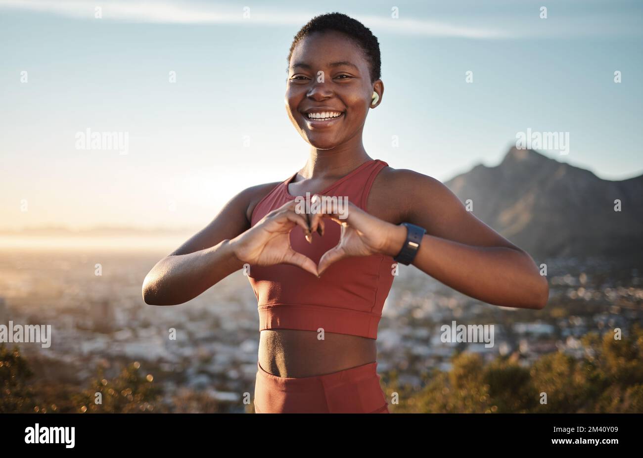 Black woman, fitness and heart hands on mountain with music for outdoor ...