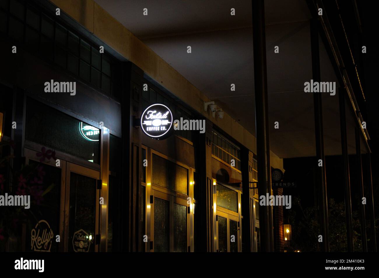 An illuminated led coffee shop sign and side buildings in the downtown ...