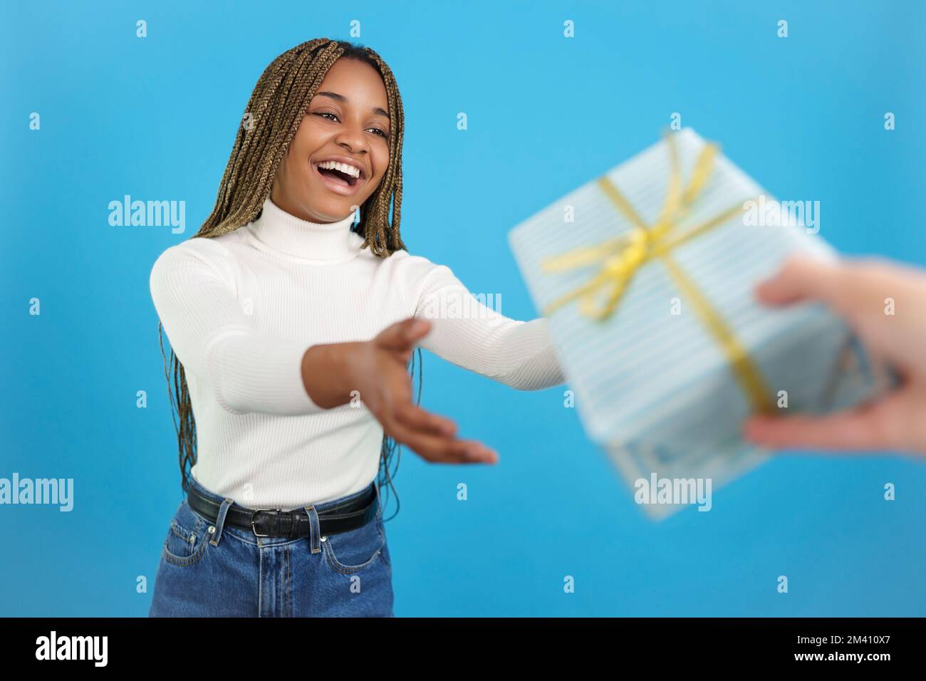 Happy casual african woman receiving a gift Stock Photo - Alamy