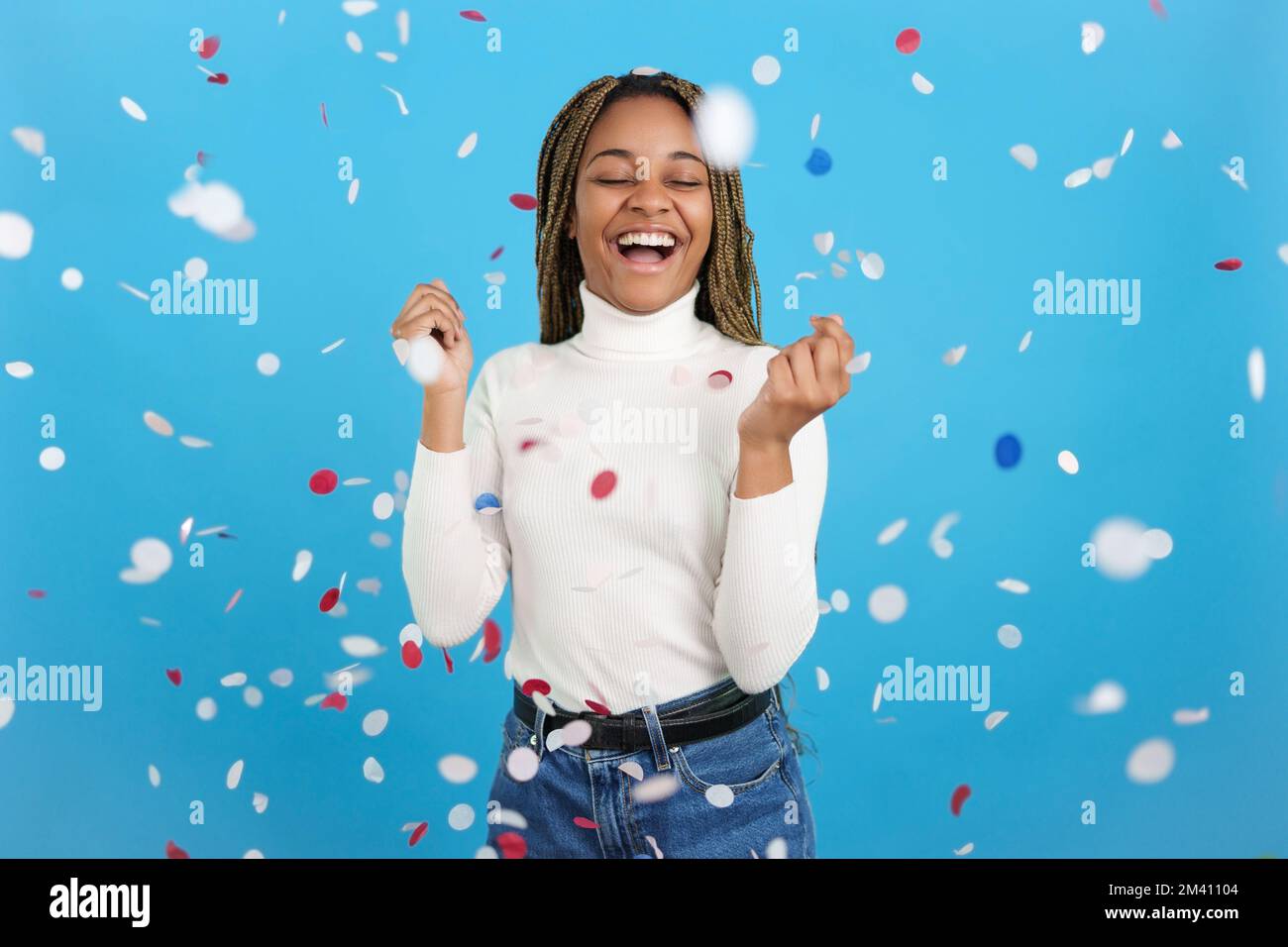 Excited African woman surrounded by flying confetti Stock Photo - Alamy