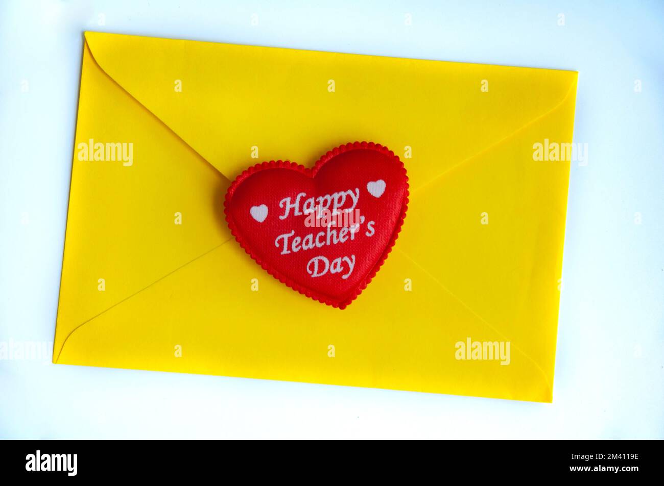 Happy teacher's day text on heart shape with yellow envelop background ...