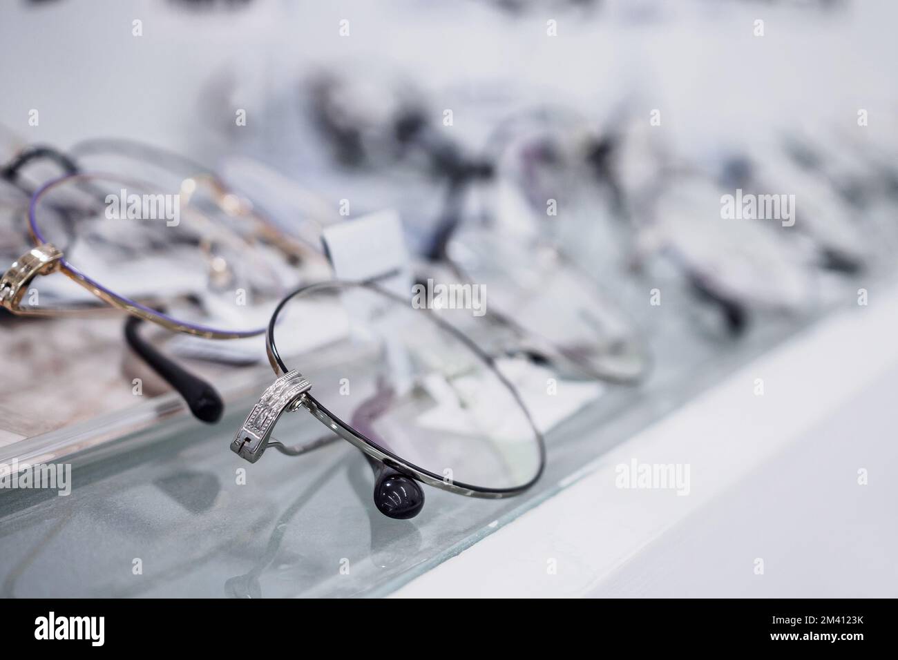 Eye glasses on window display shelves in optics store Stock Photo - Alamy