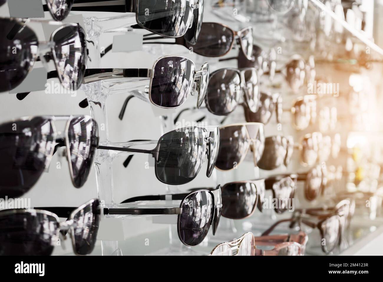 Sunglasses on display shelves in glasses store Stock Photo - Alamy