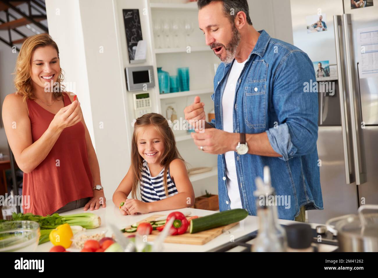 Making dinner prep a family affair. an adorable little girl cooking ...