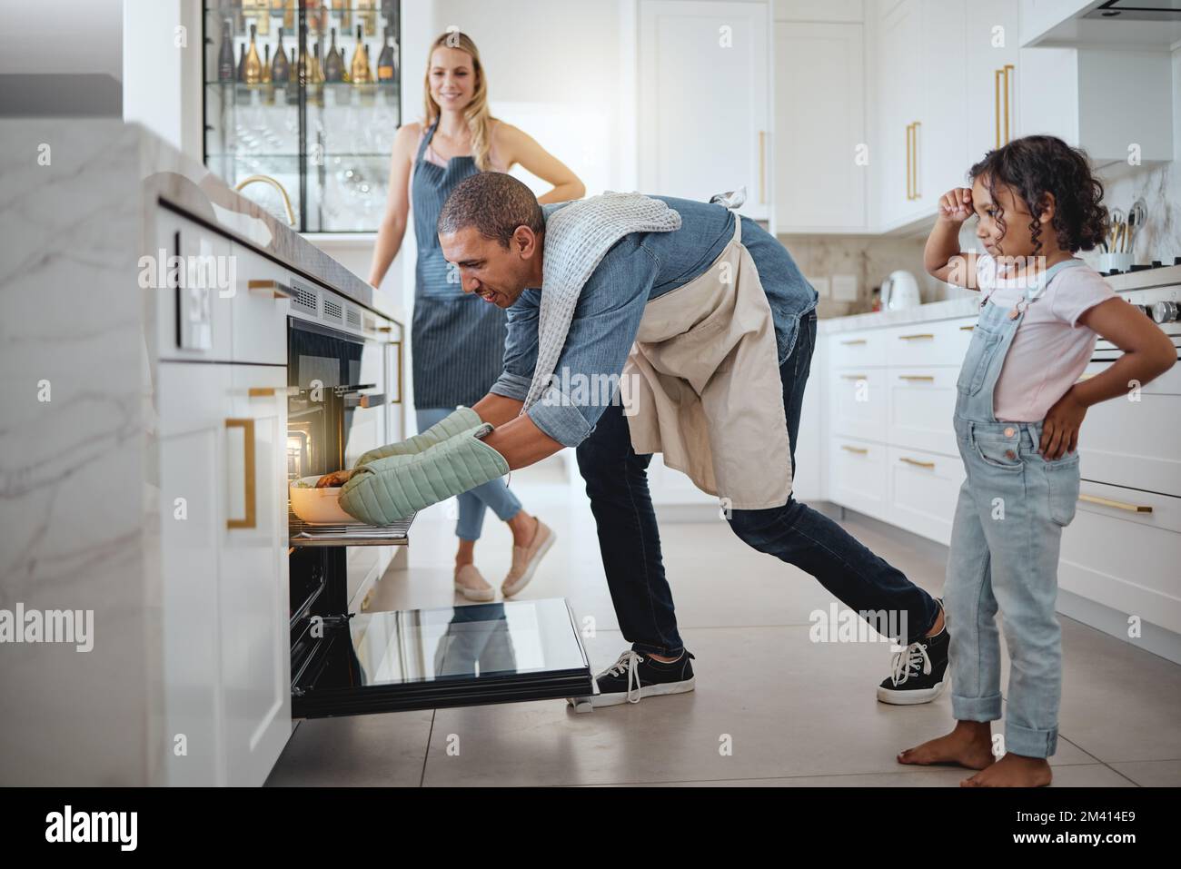 Kitchen, family and father cooking in oven to prepare meal, lunch and ...