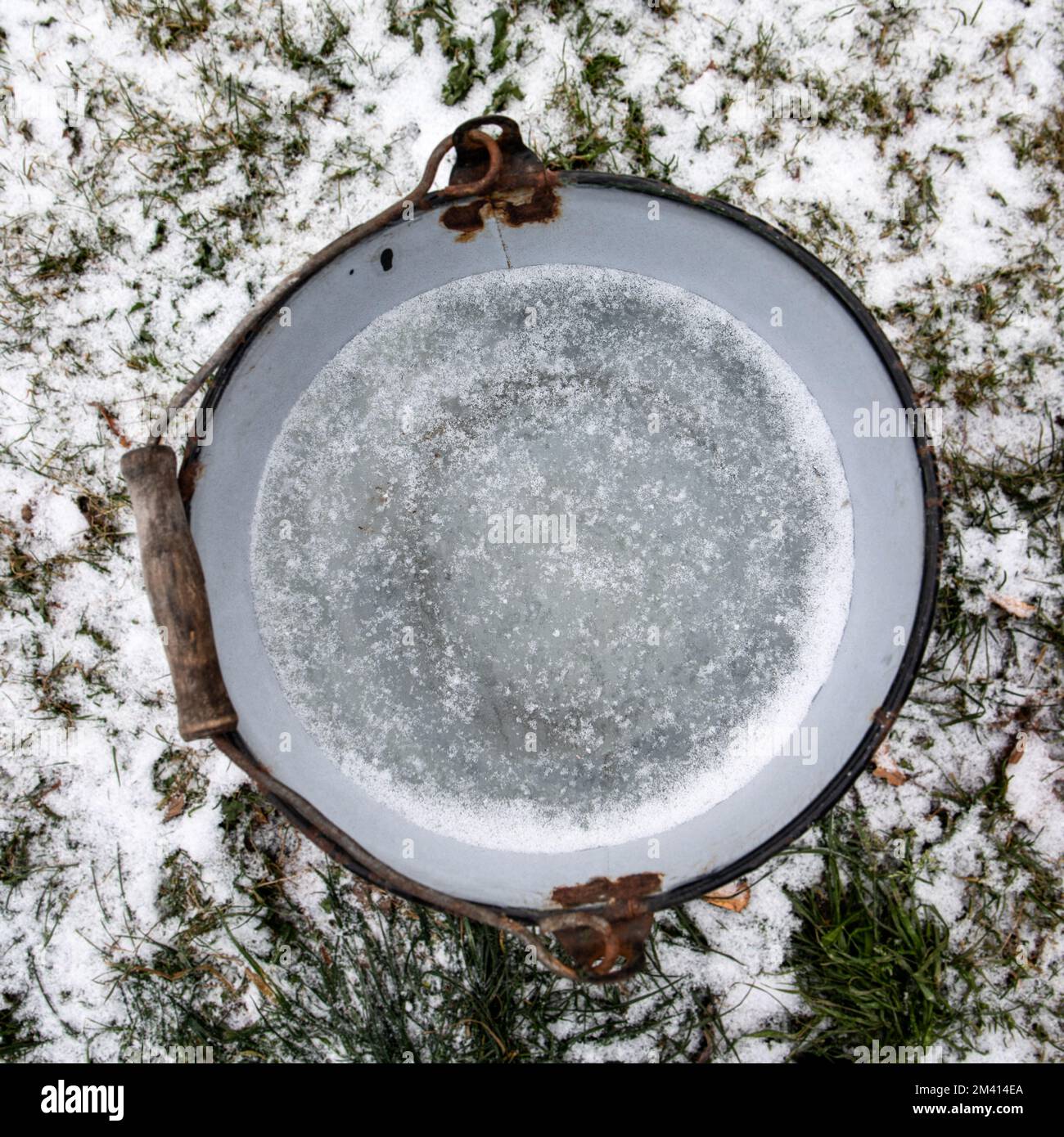 Frozen water, ice in a metal bucket. Weather and winter Stock Photo - Alamy