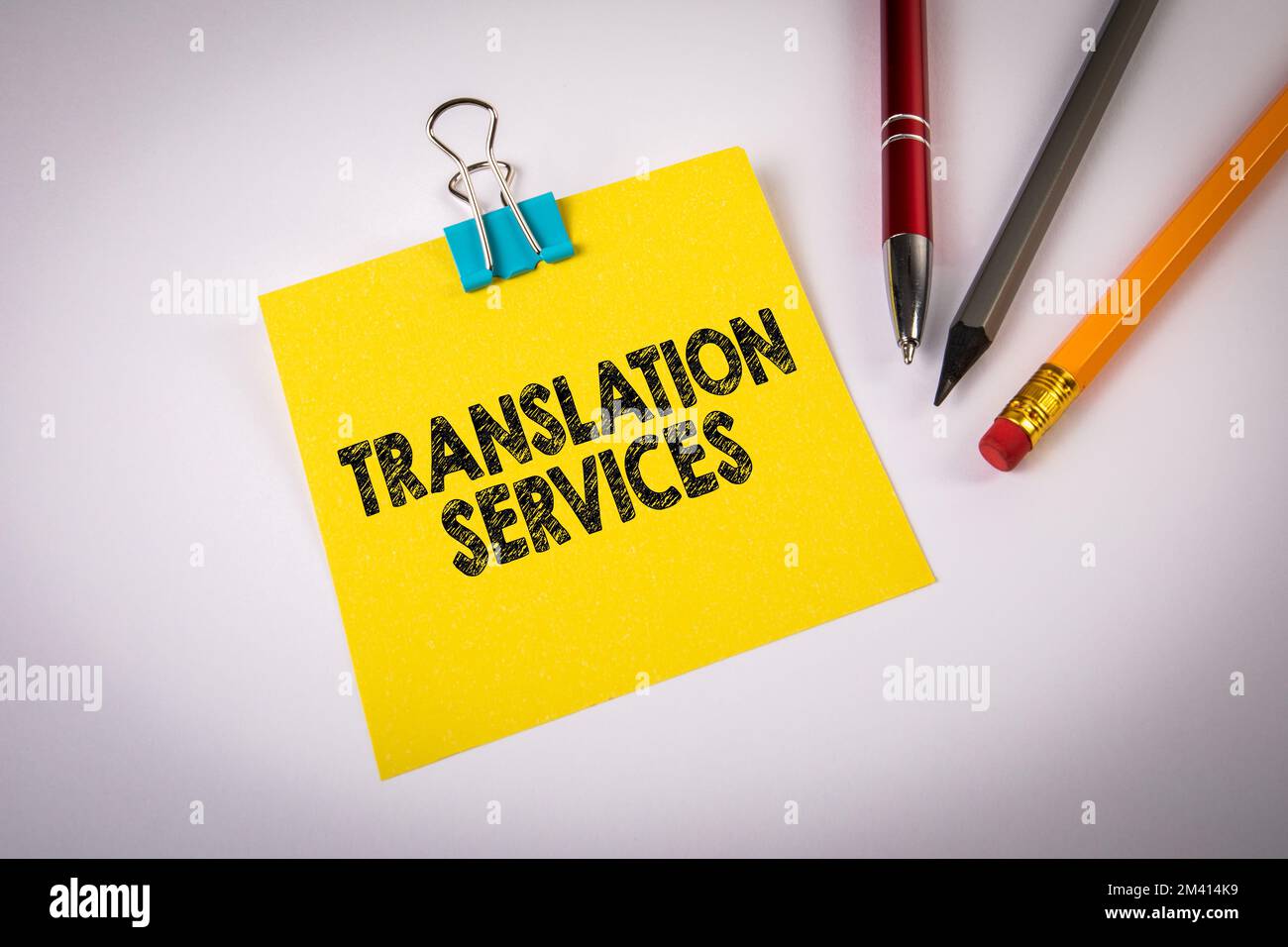 TRANSLATION SERVICES. Text on yellow sticky note. White office desk ...