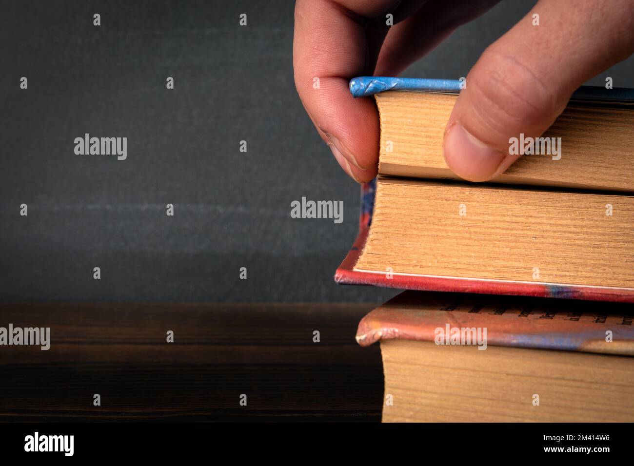Stack of books and a woman's hand Stock Photo - Alamy