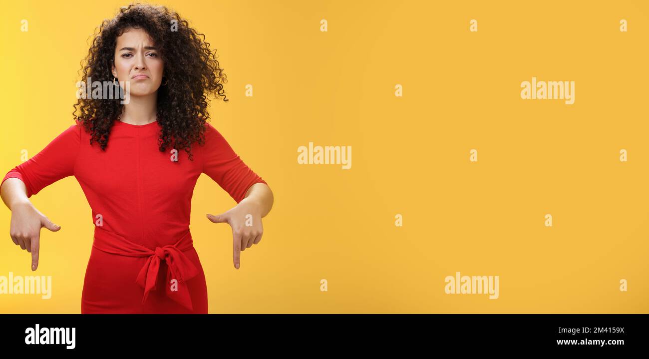 Gloomy disappointed cute silly curly-haired female in red dress ...
