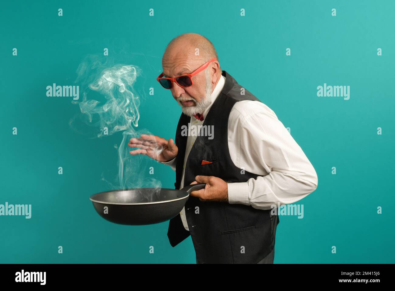 A man with a burning pan in his hands Stock Photo - Alamy
