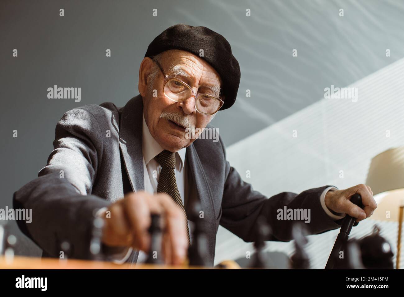 Portrait of serious old man playing chess in room Stock Photo - Alamy