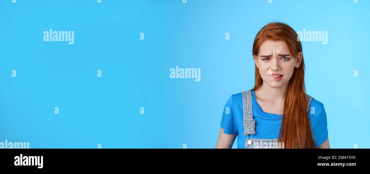 Uneasy upset redhead girl feel uncomfortable, stare frustrated, biting ...