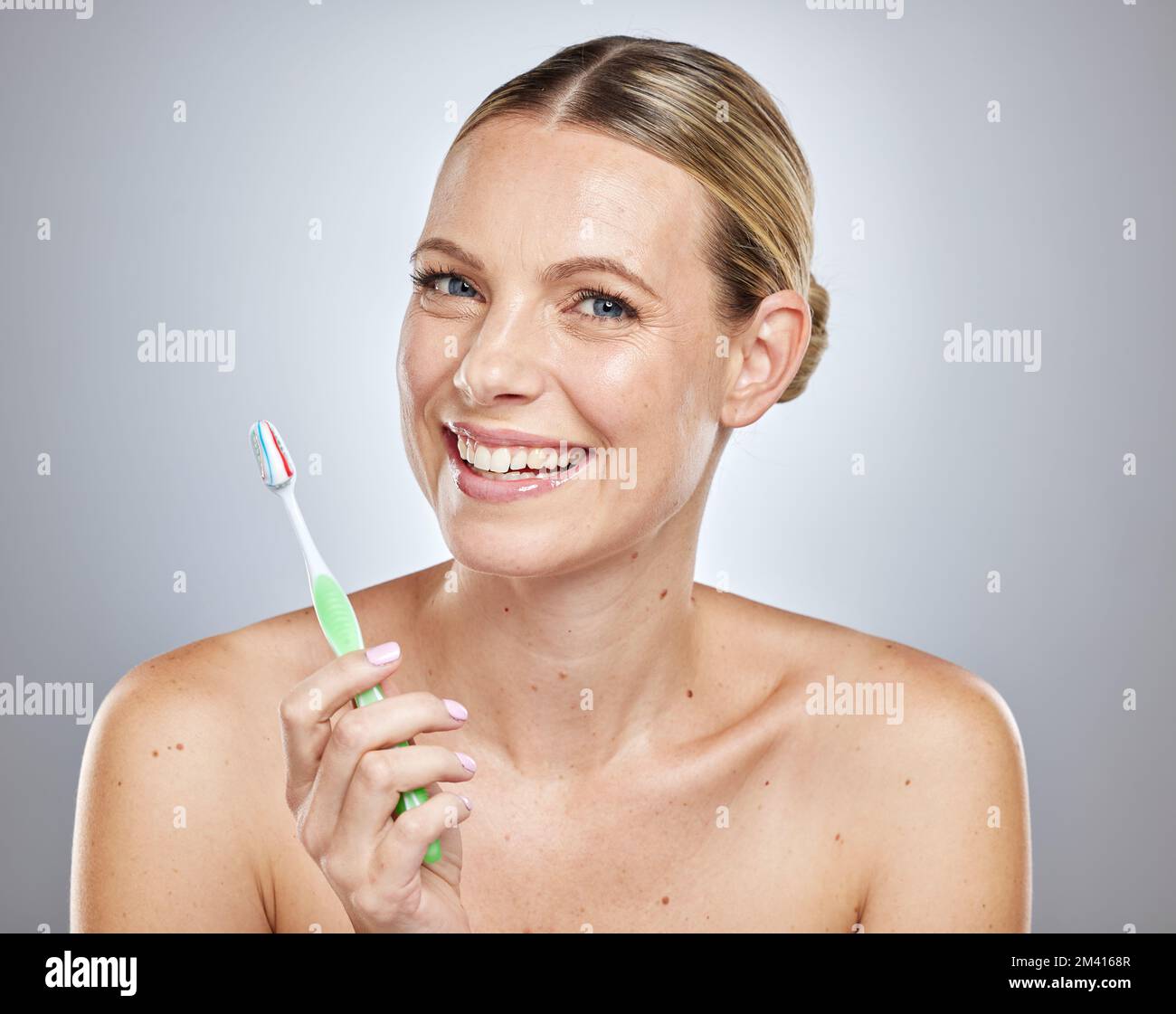 Face, teeth and woman with toothbrush in studio isolated on a gray ...