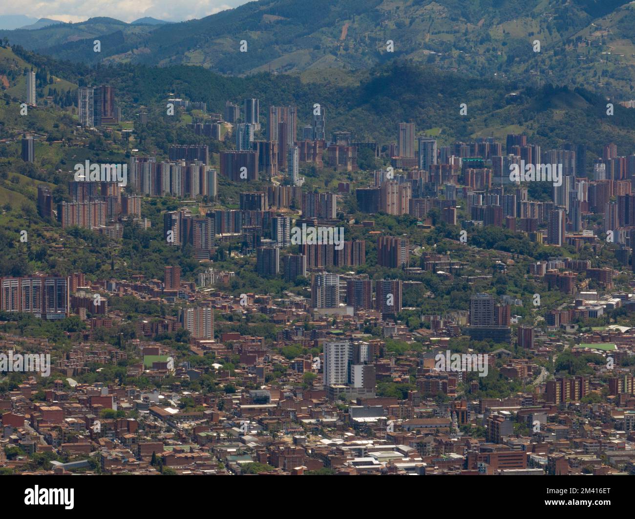 An aerial view of Medellin city with high buildings and green nature on ...
